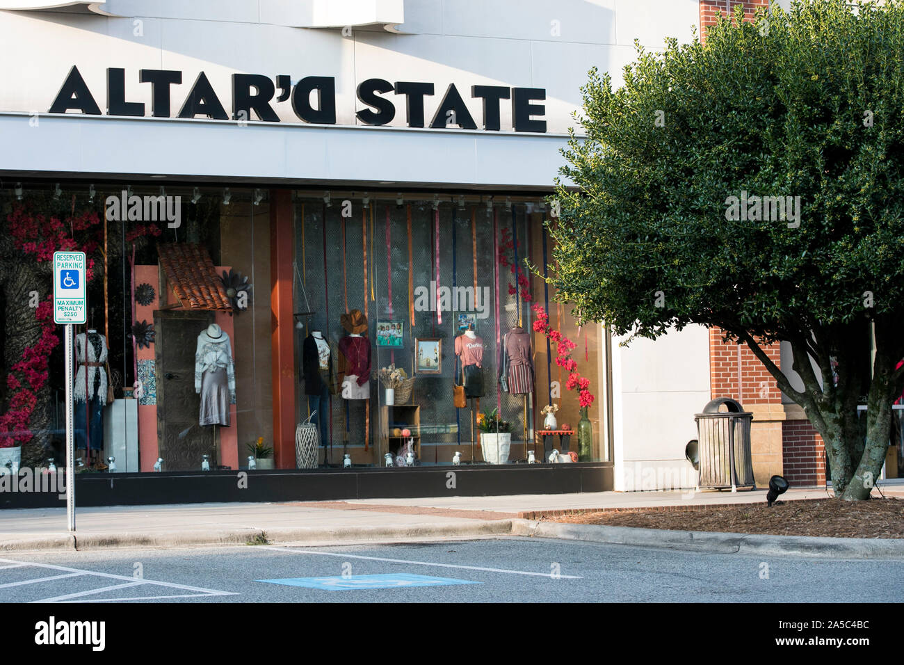 A logo sign outside of a Altar'd State retail store location in ...