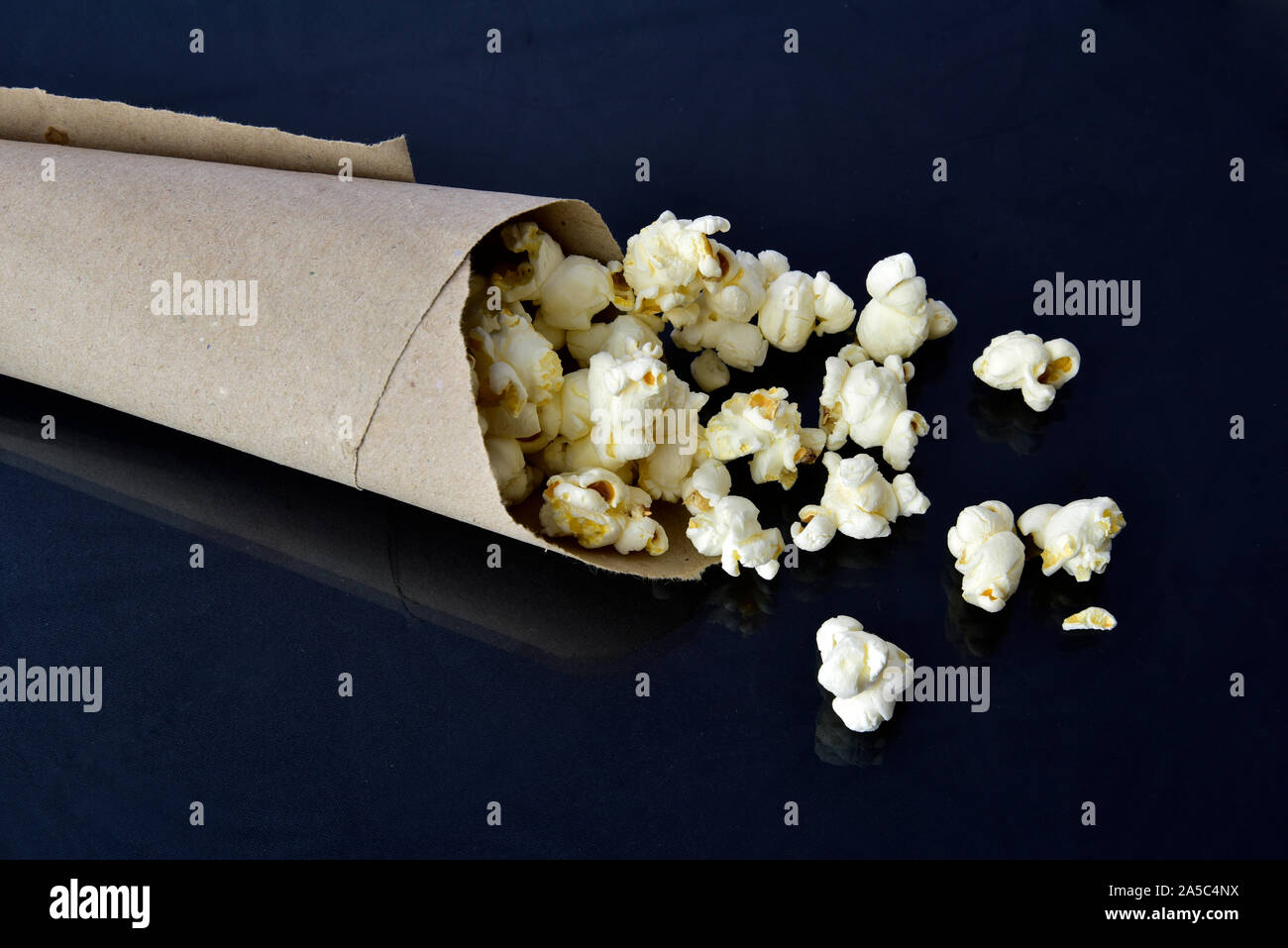 popcorn falling from paper packaging with wood background Stock Photo ...