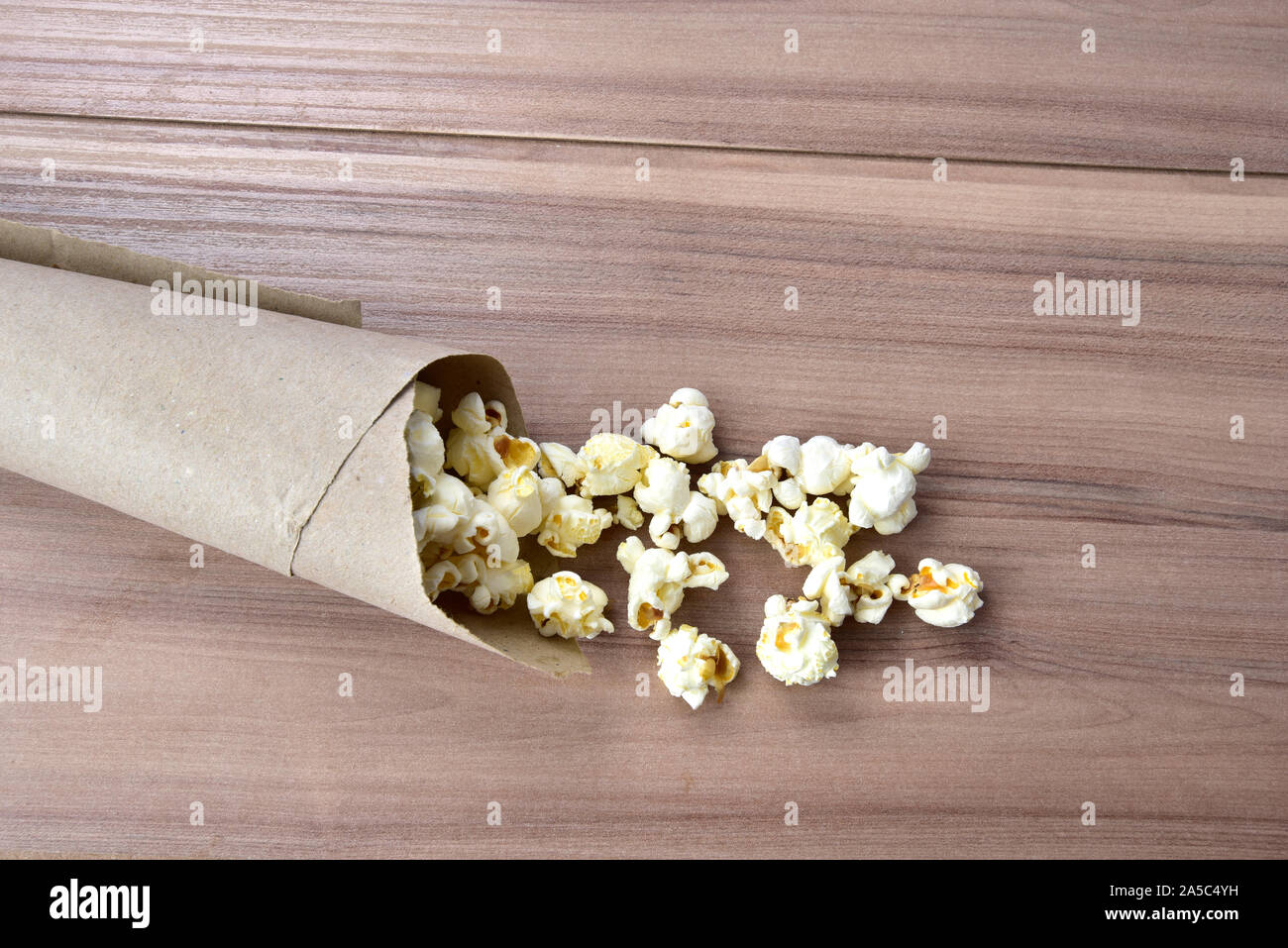 popcorn falling from paper packaging with wood background Stock Photo ...