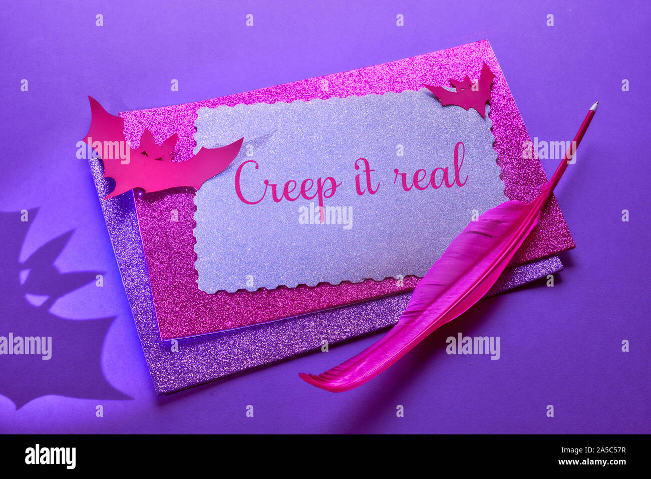 Creative purple and pink Halloween background with stack of glittering ...