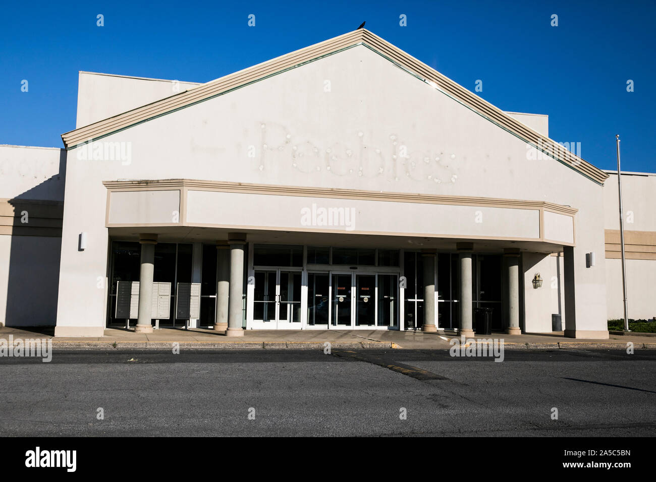 The faded outline of a logo sign outside of a closed and abandoned ...