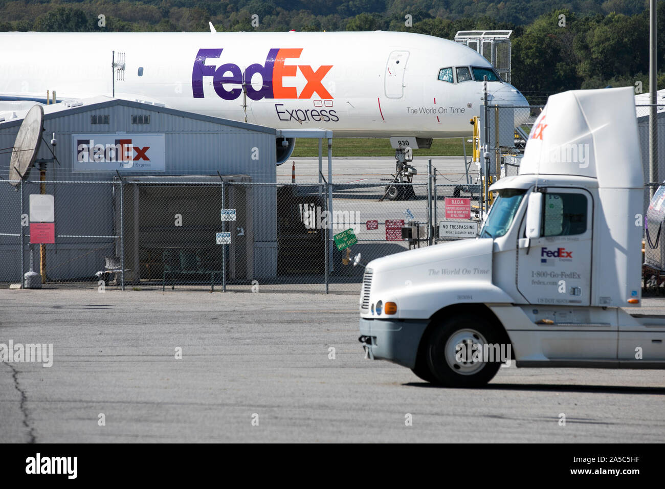 A FedEx Boeing 757 cargo plane and trucks at a FedEx cargo facility in ...