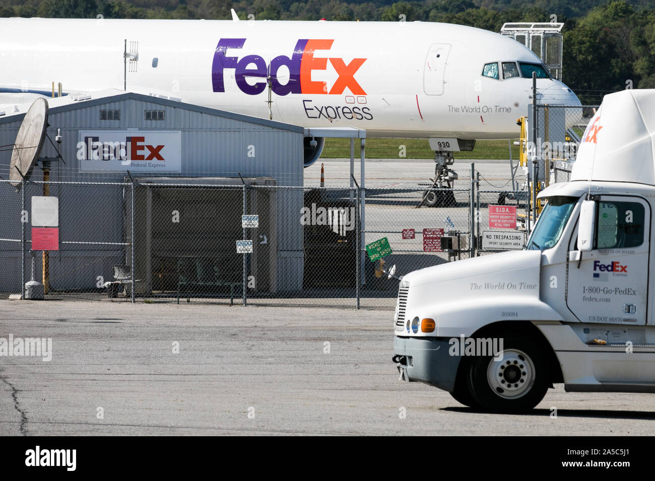 A FedEx Boeing 757 cargo plane and trucks at a FedEx cargo facility in ...