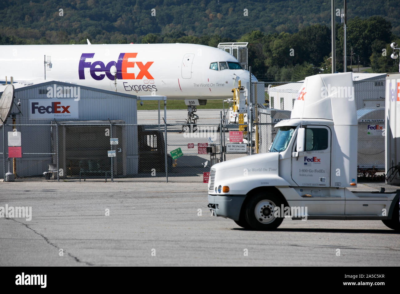 A FedEx Boeing 757 cargo plane and trucks at a FedEx cargo facility in ...