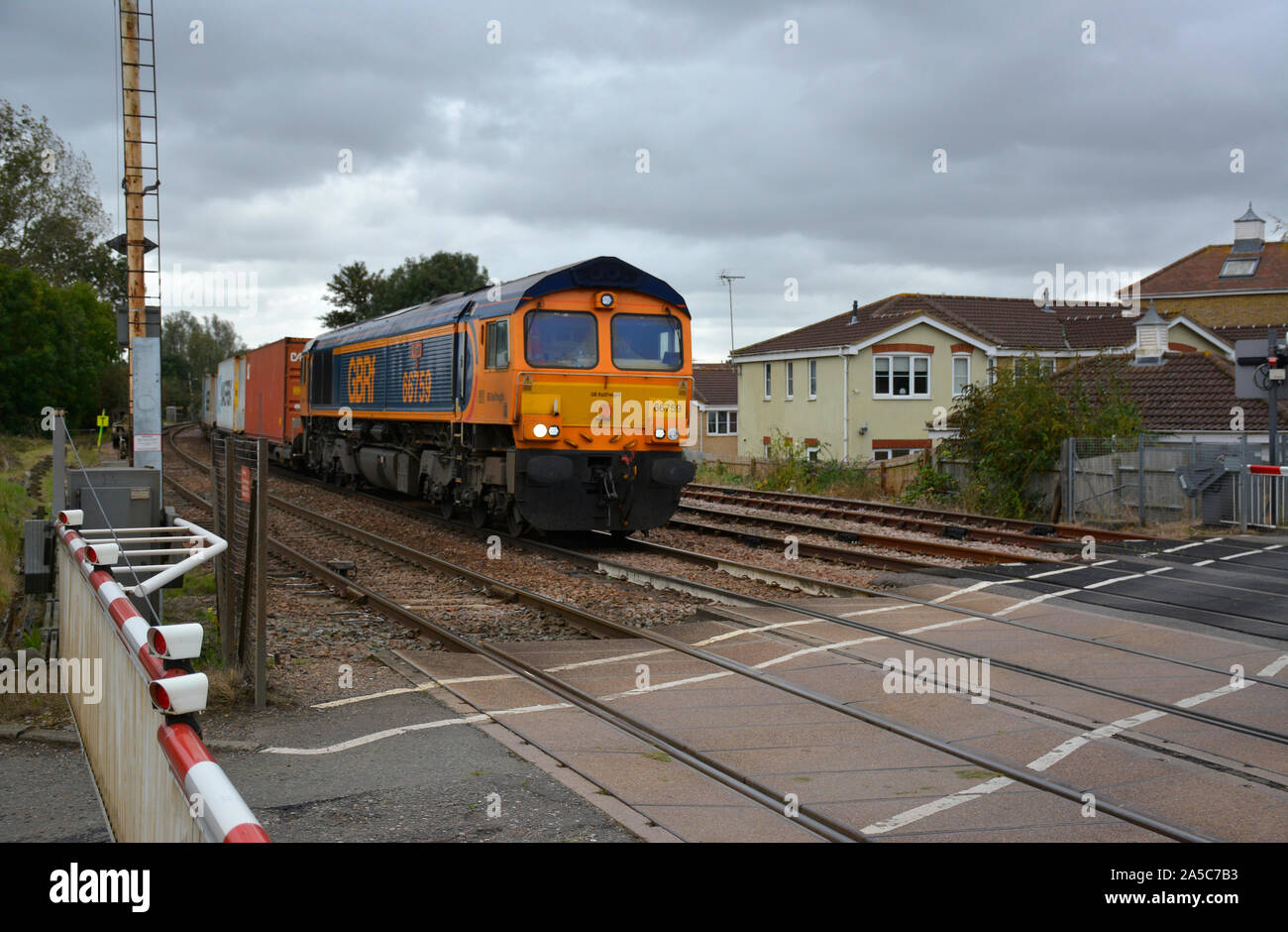 Train passes level crossing with barrier hi-res stock photography and ...