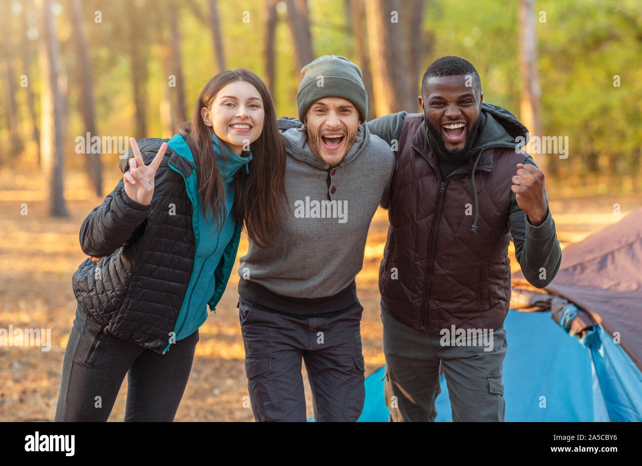 Emotional group of tourists posing over forest background Stock Photo ...