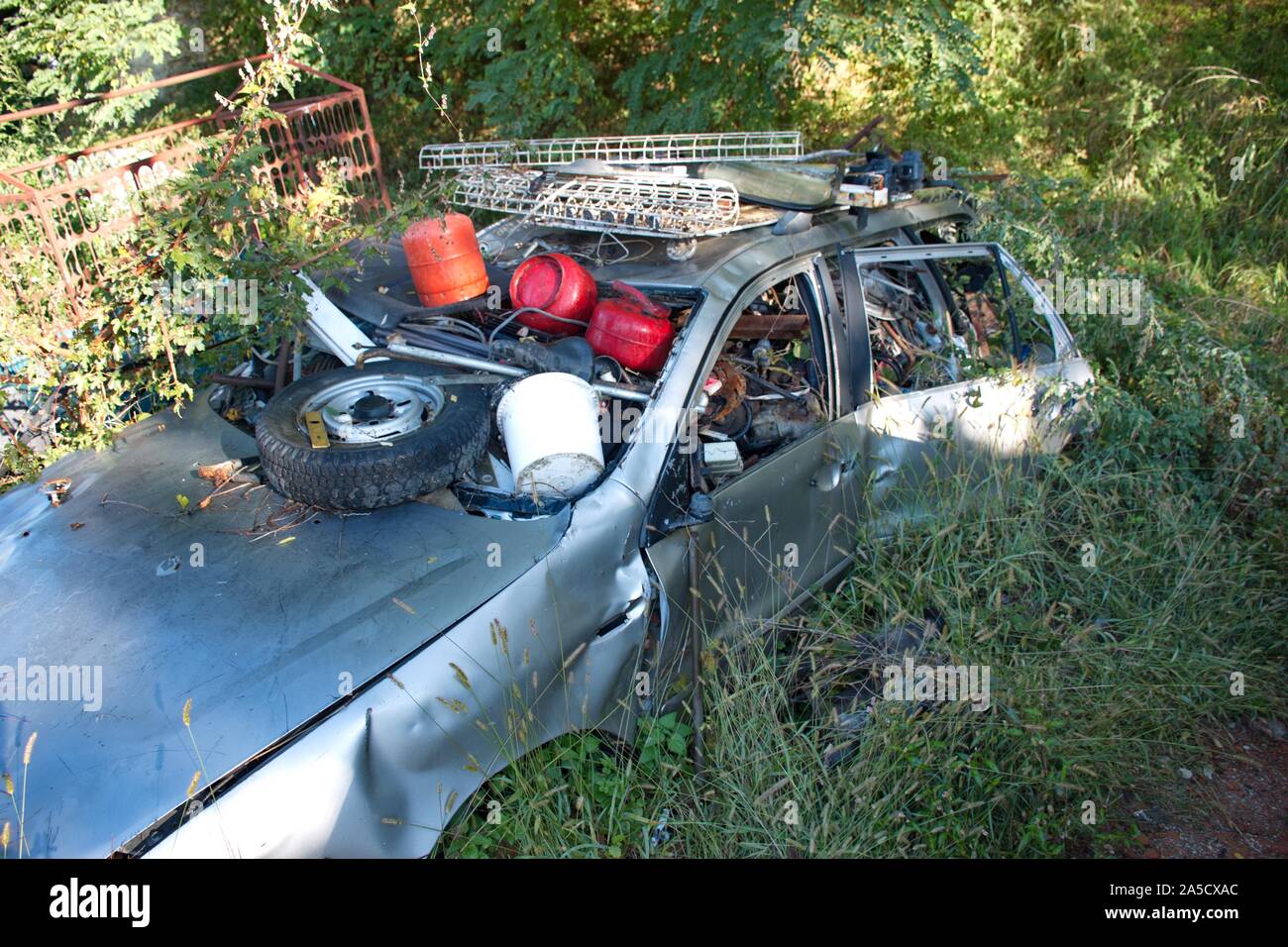 Abandoned rusty car full of garbage left in nature Stock Photo - Alamy