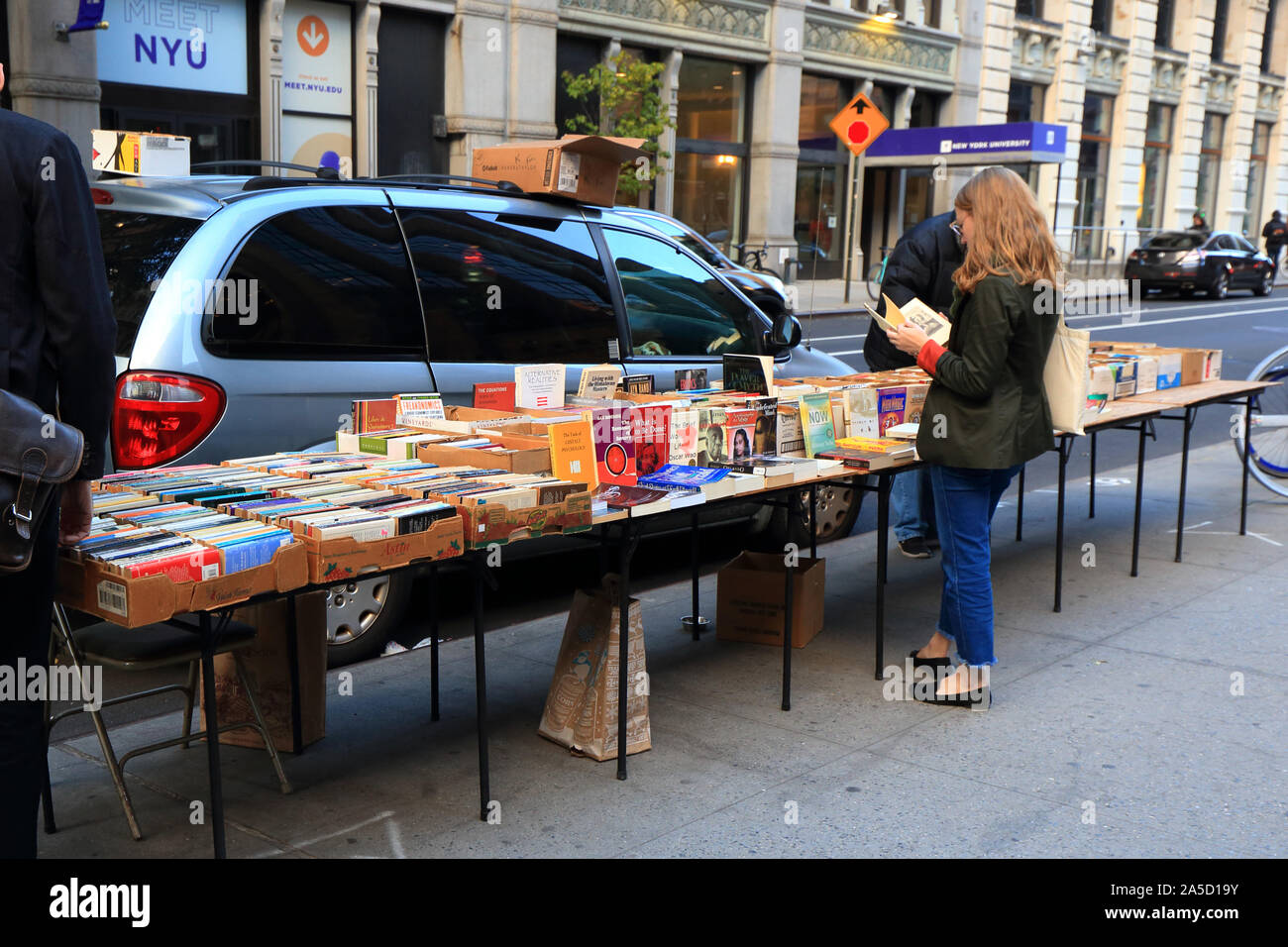 People browsing used books at a sidewalk bookseller in New York City ...