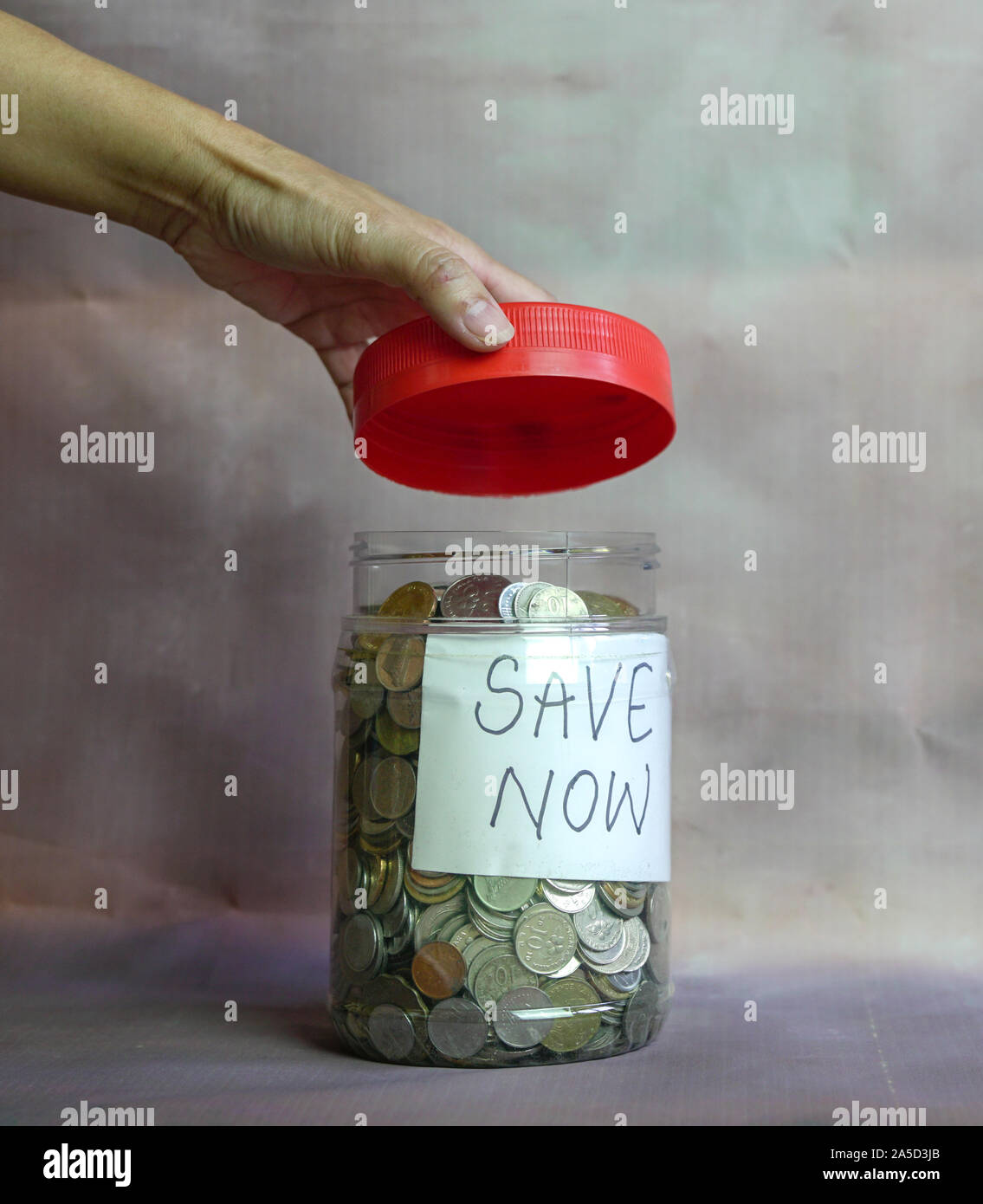 Savings concept. Coins saved inside container with Save Now words ...