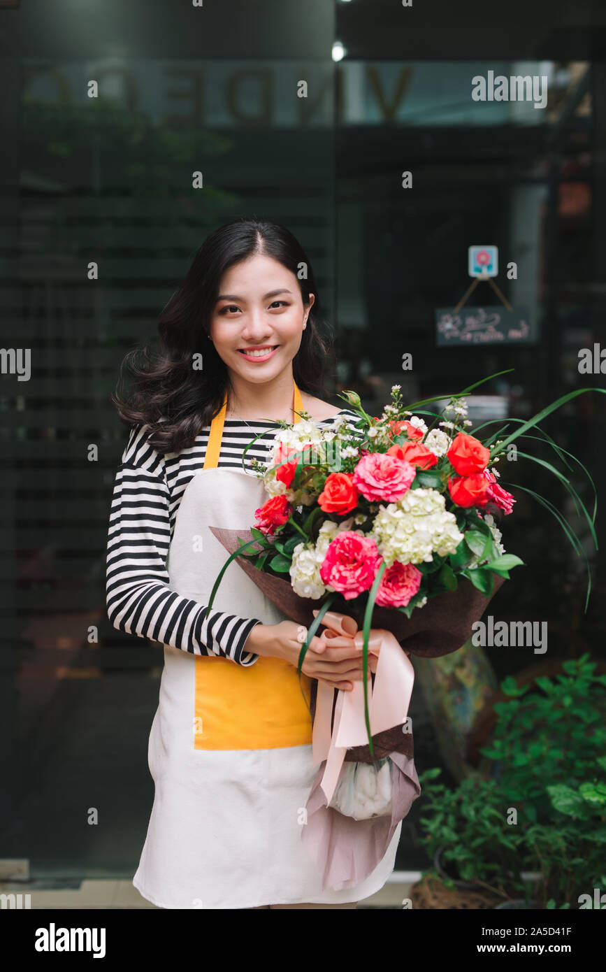 Female sales assistant working as florist and holding bouquet Stock ...