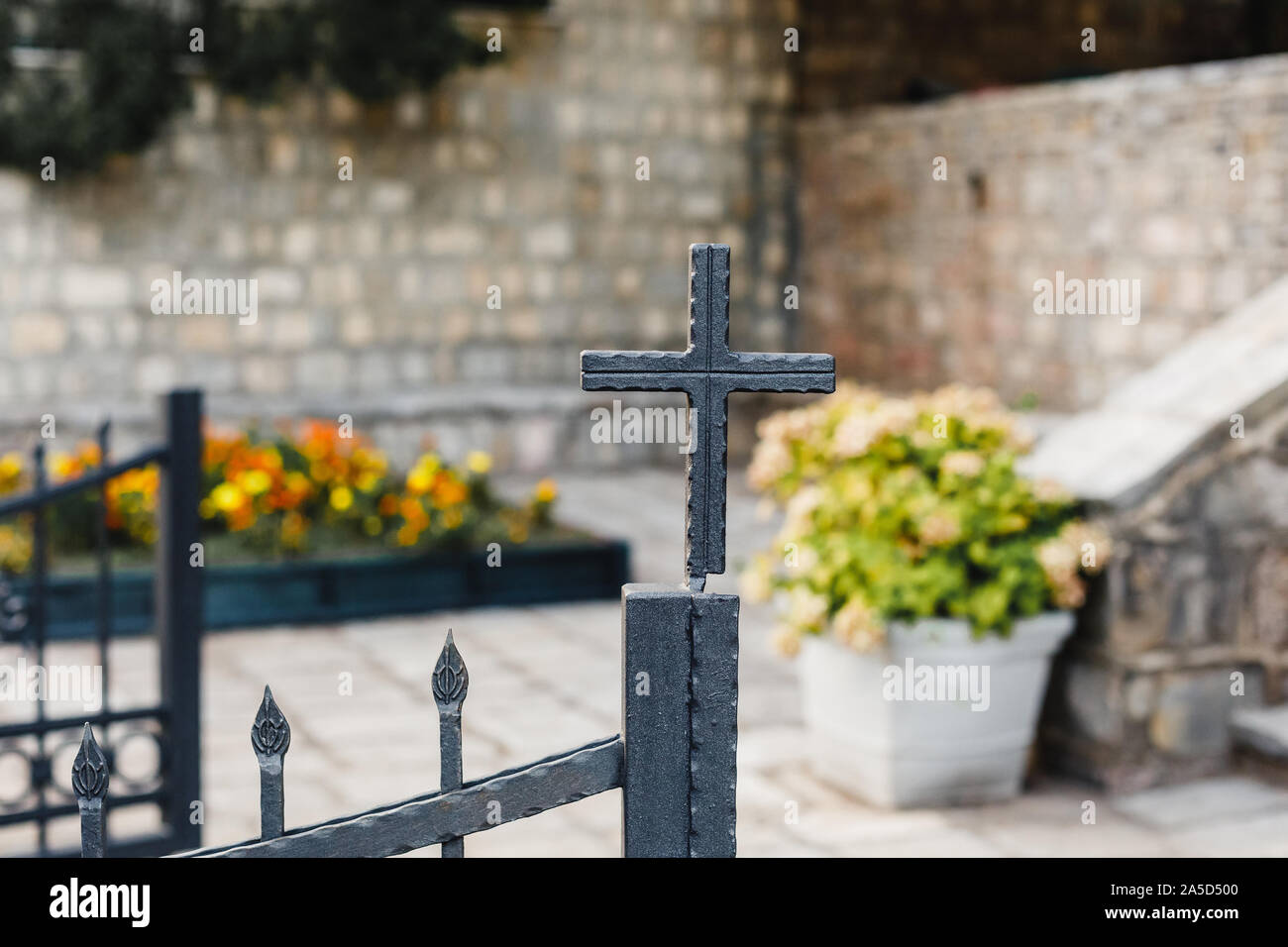 Church yard with flowers and cross on iron fence Stock Photo - Alamy