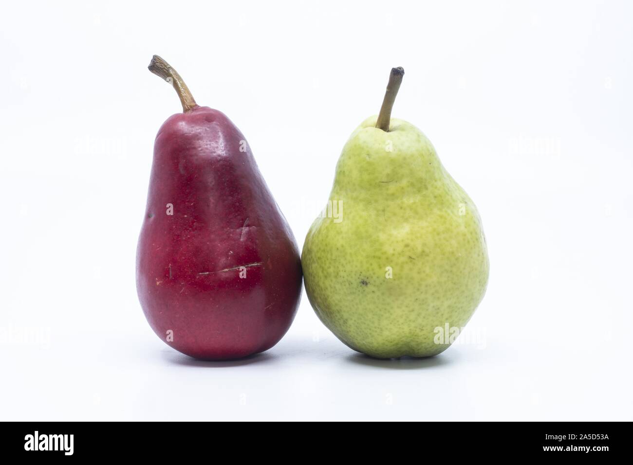 Closeup shot of red and green pears near each other on a white surface ...