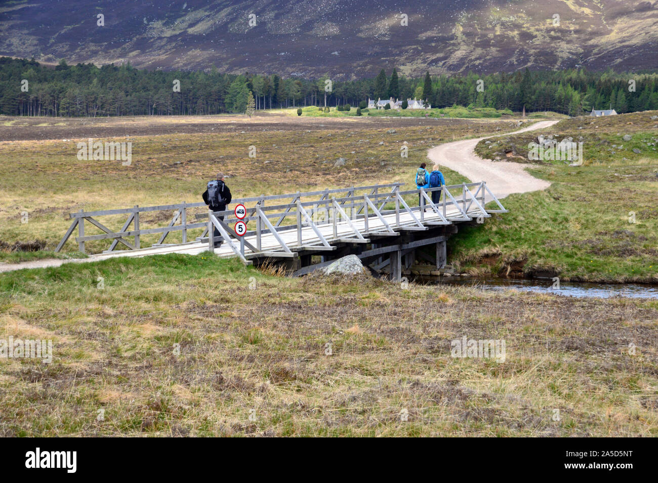Three Hikers Walking over Wooden Footbridge over the River Muick to the ...
