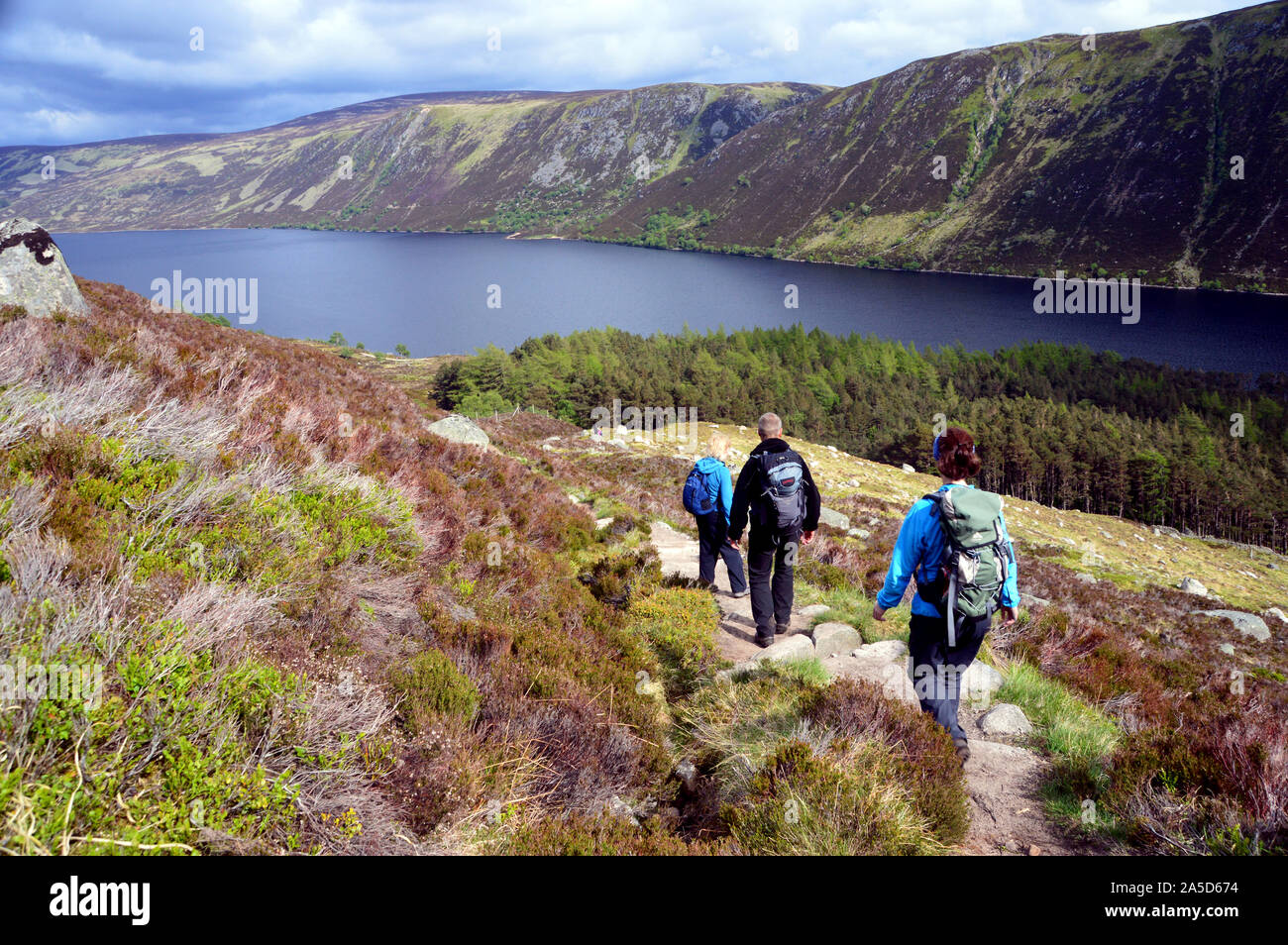 Three Hikers Walking to Loch Muick after Climbing the Scottish Mountain ...