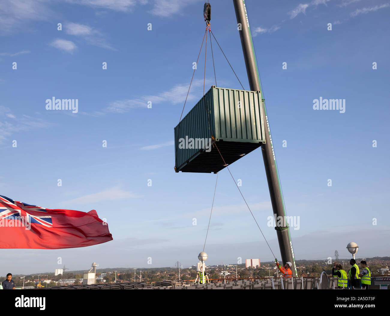 A large green metal Container is hoisted onto a cruise ship in ...