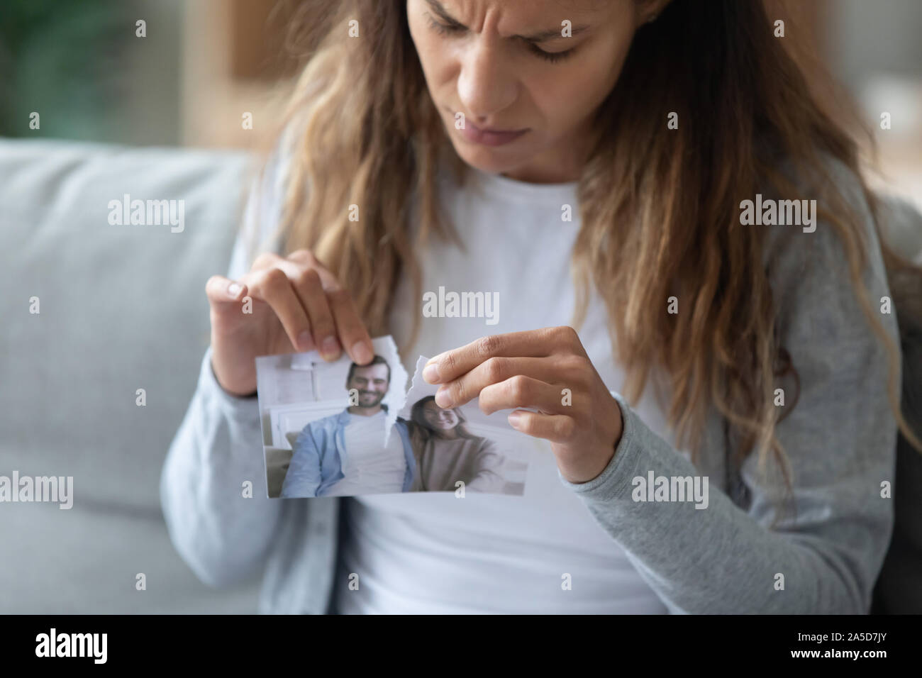 Stressed girl tearing photo with boyfriend or husband in half Stock ...
