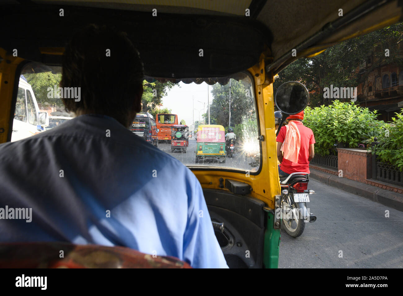 A unidentified driver is riding an auto rickshaw through the busy ...
