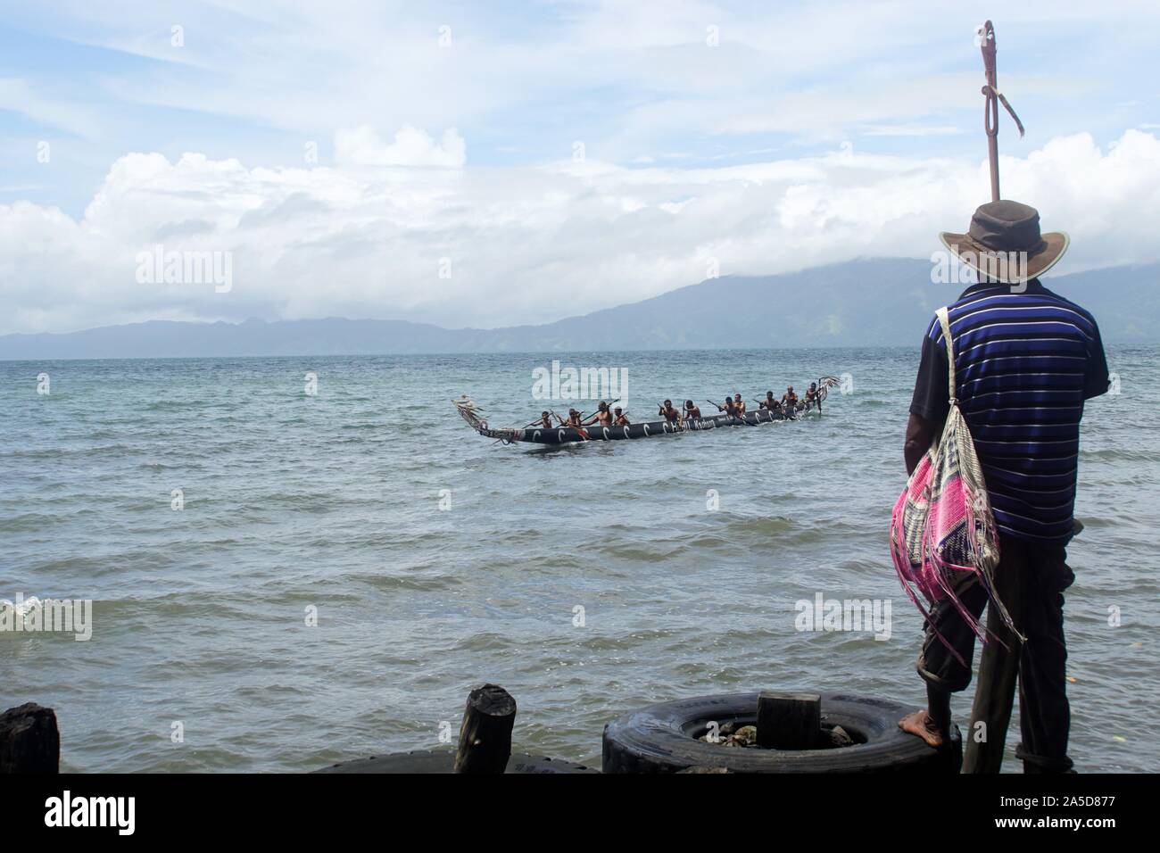 Man watching a traditional Kula Canoe come back to the Shore Stock ...