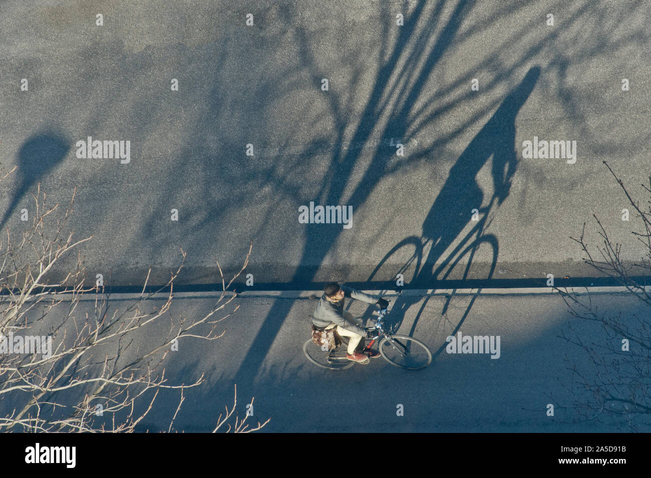 Man travels with bike withe his long shadow on the road Stock Photo - Alamy