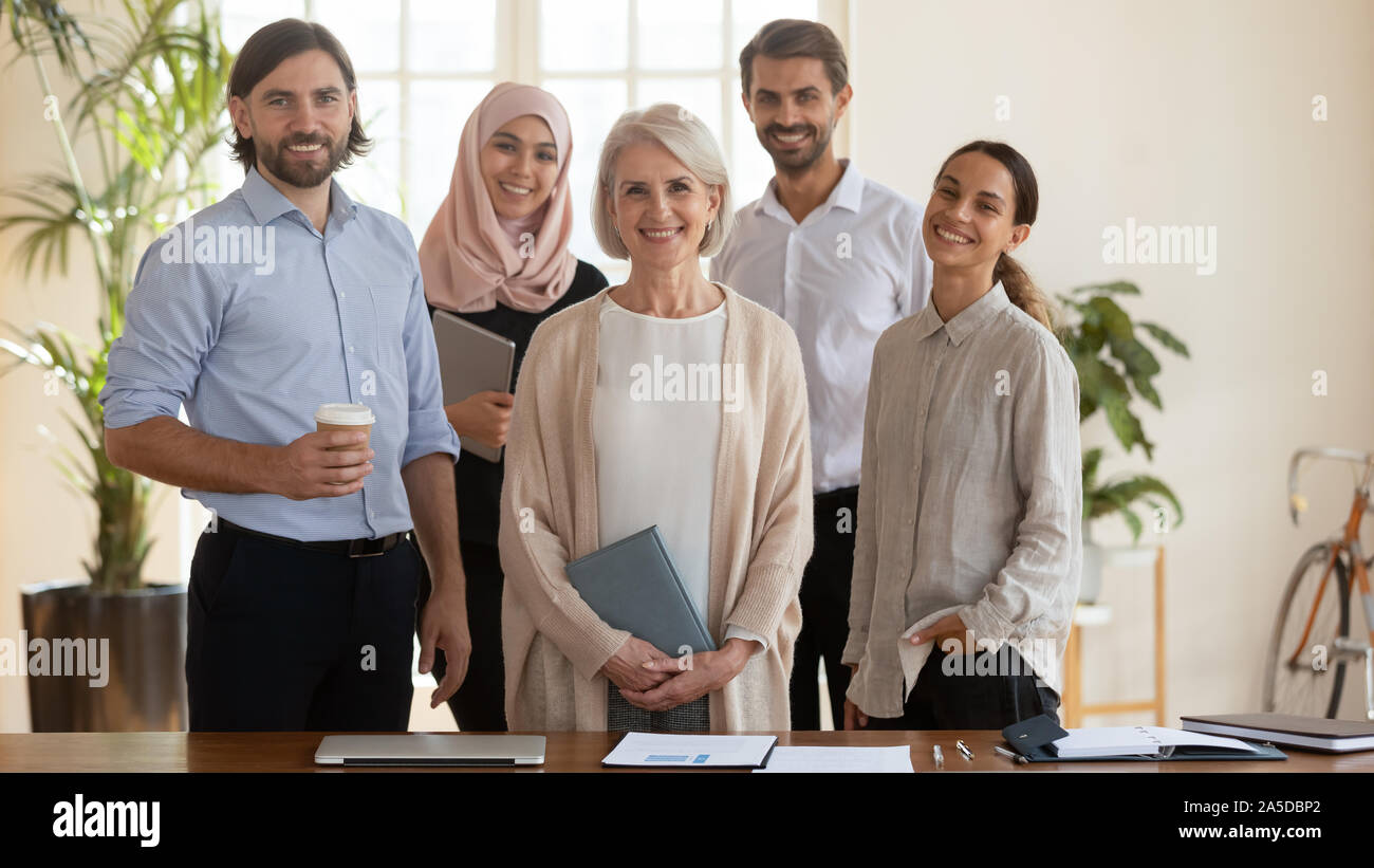 Happy multicultural team with old leader stand look at camera Stock ...