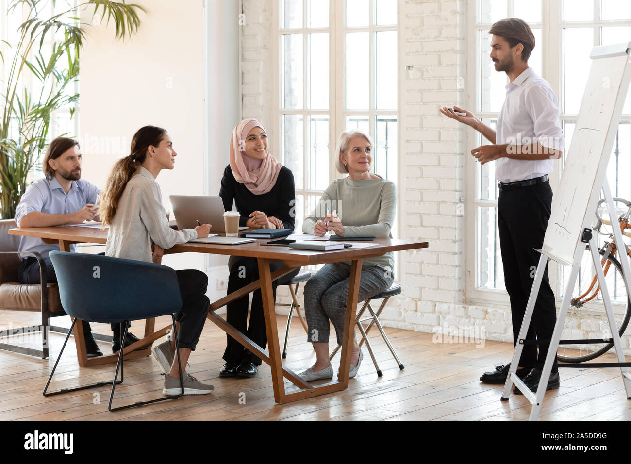 Confident businessman trainer give flip chart presentation at corporate ...