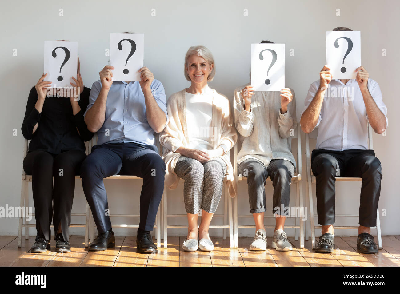 Happy mature businesswoman professional sitting among people holding ...