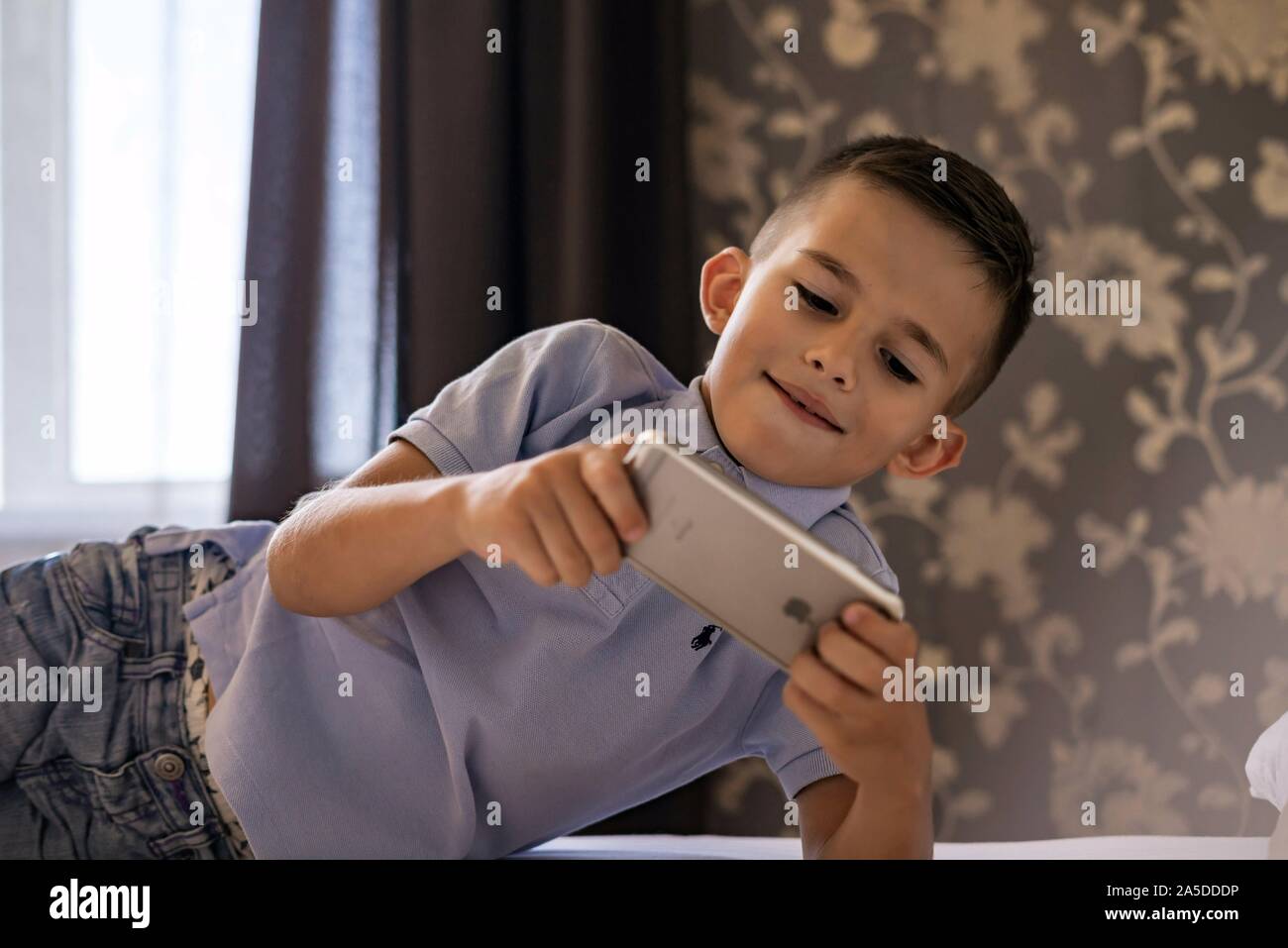 Boy playing game on smartphone Stock Photo - Alamy