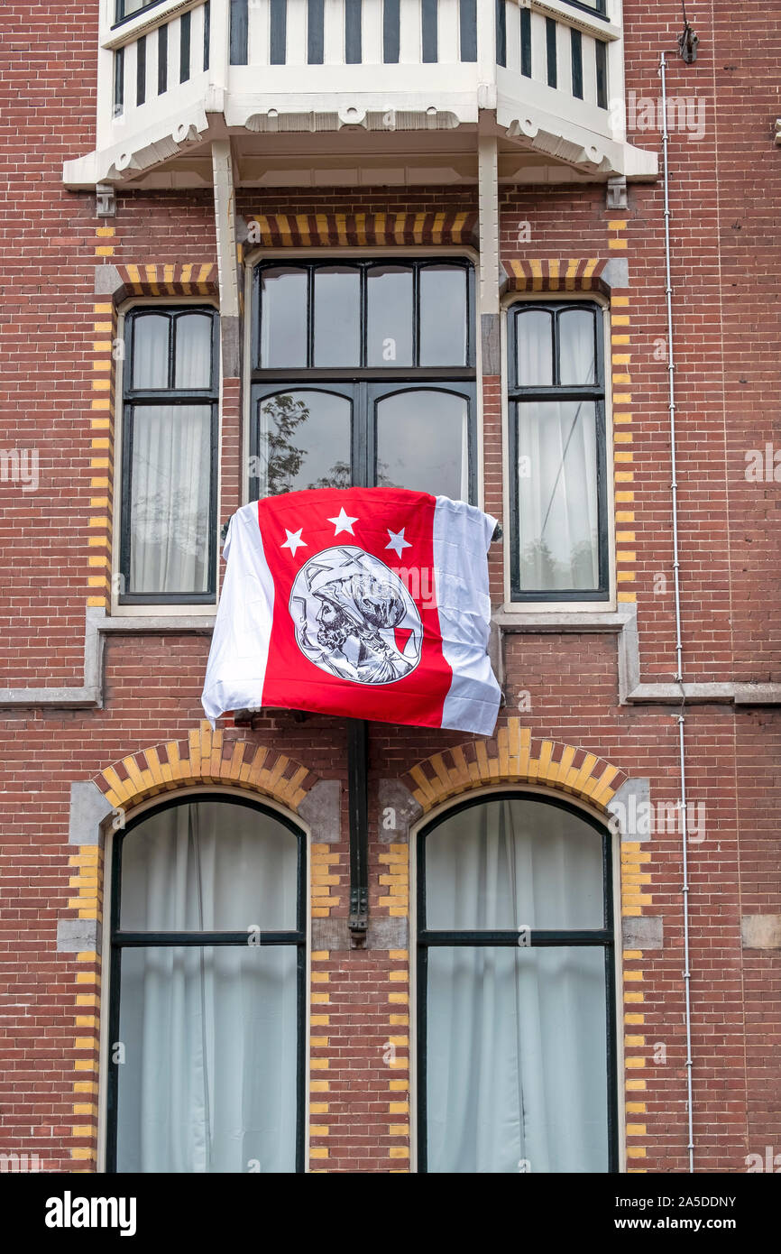 Amsterdam, Netherlands - May 16, 2019: Dutch facade with the Ajax flag ...