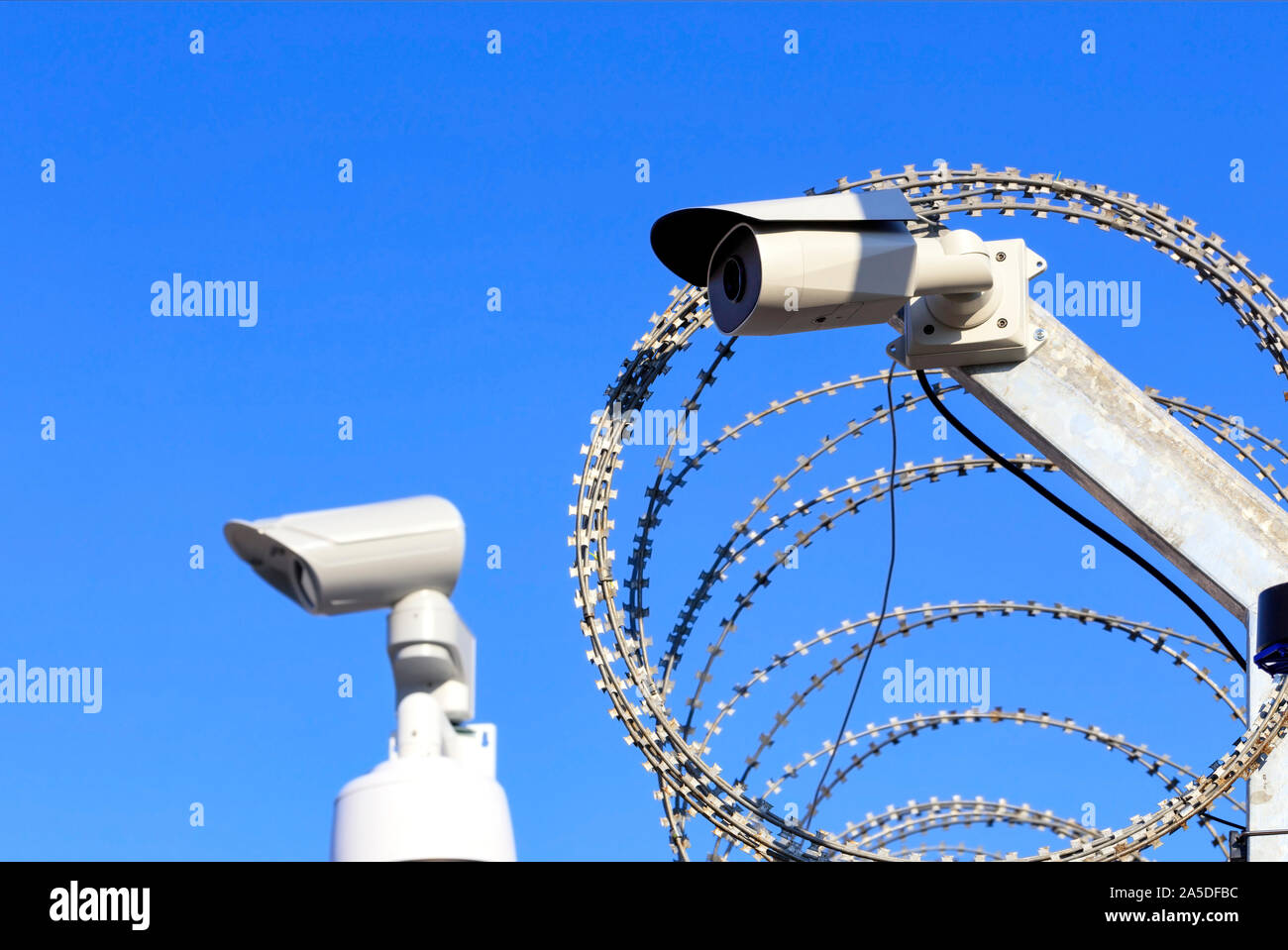 Territory perimeter security. Barbed wire fence and cameras protect ...