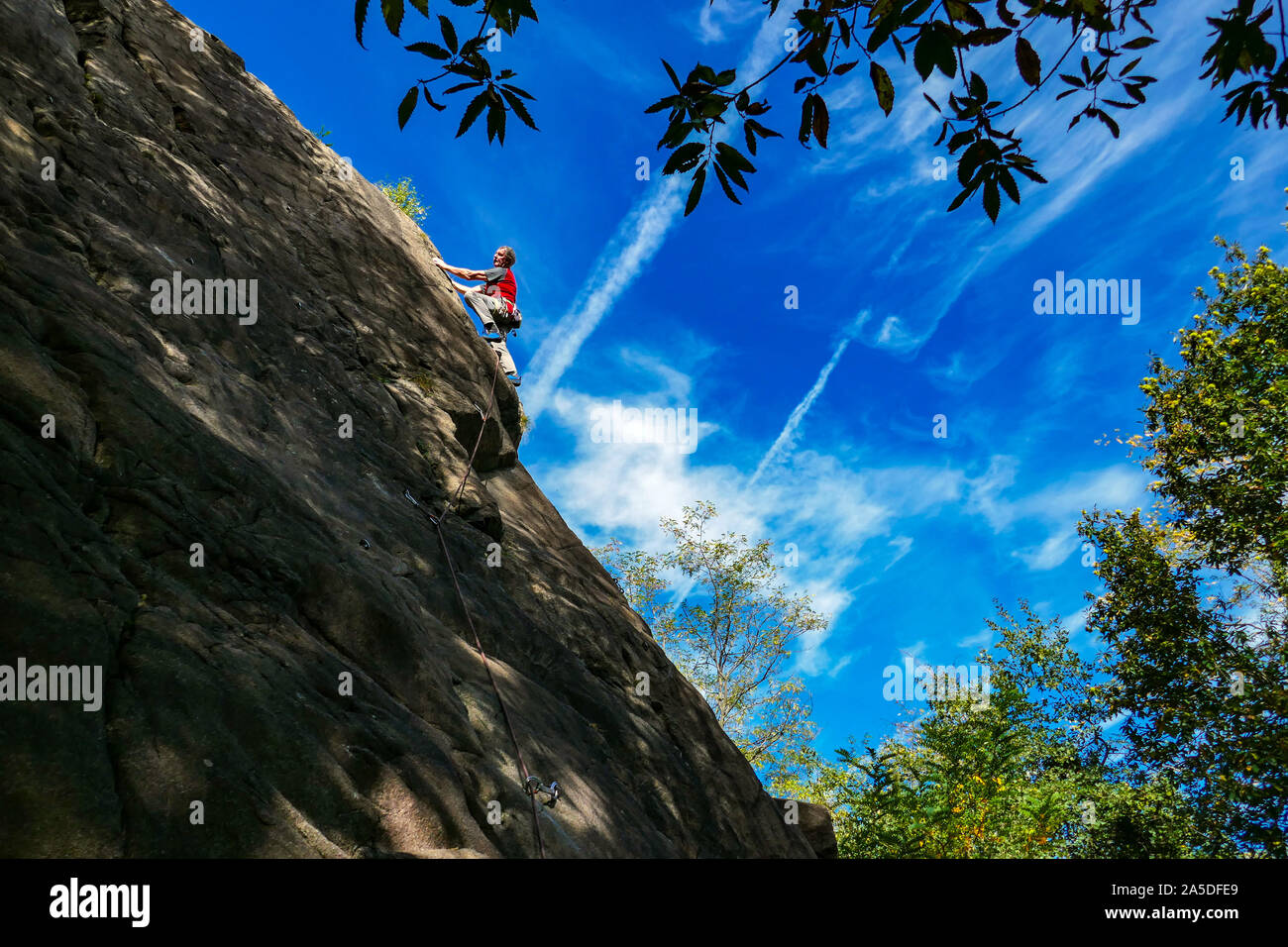 Rock climber in red at granite cliff of Auzat, The Ariege region ...