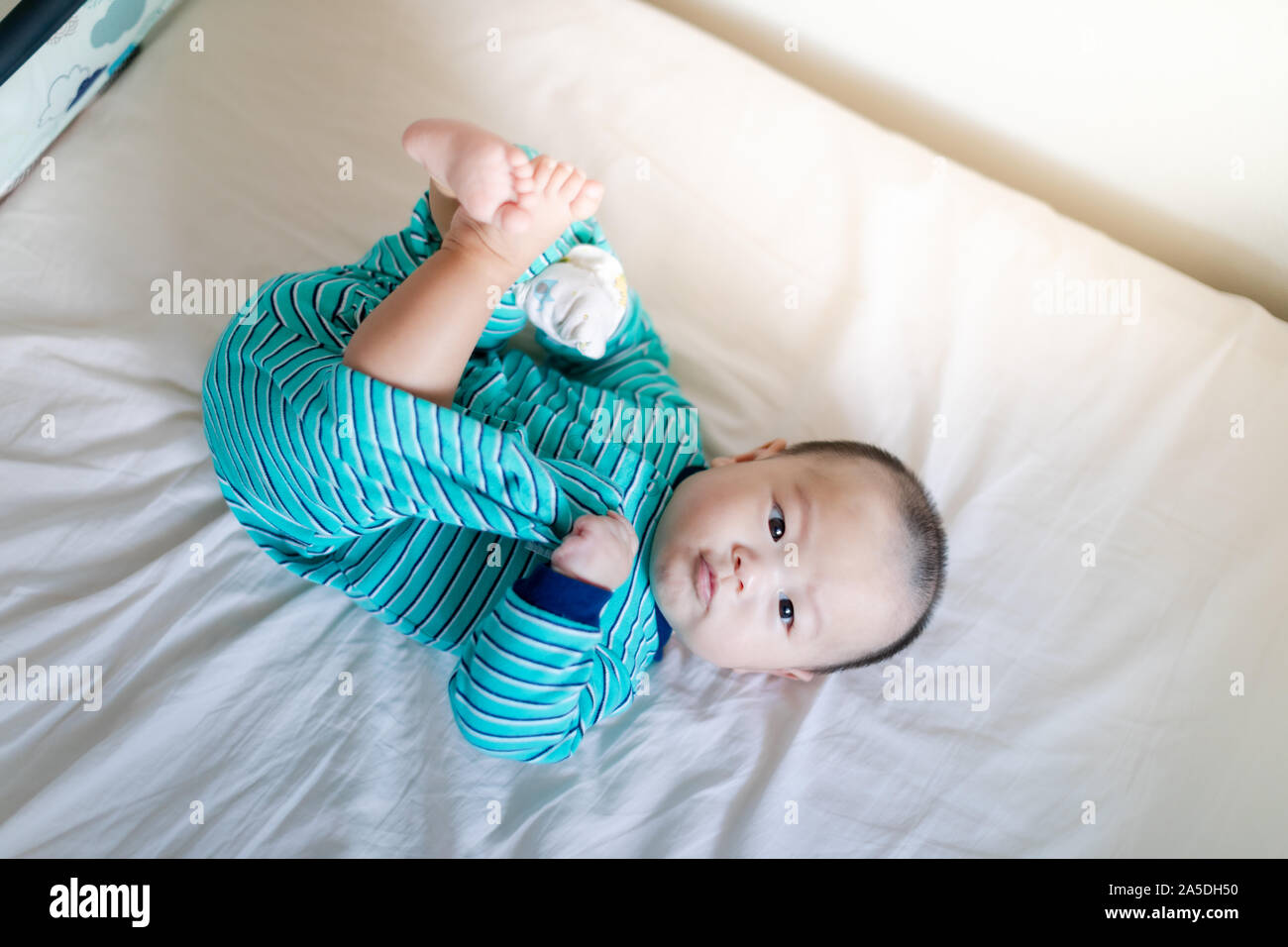 Cute baby boy rolling on bed and playing at home Stock Photo - Alamy