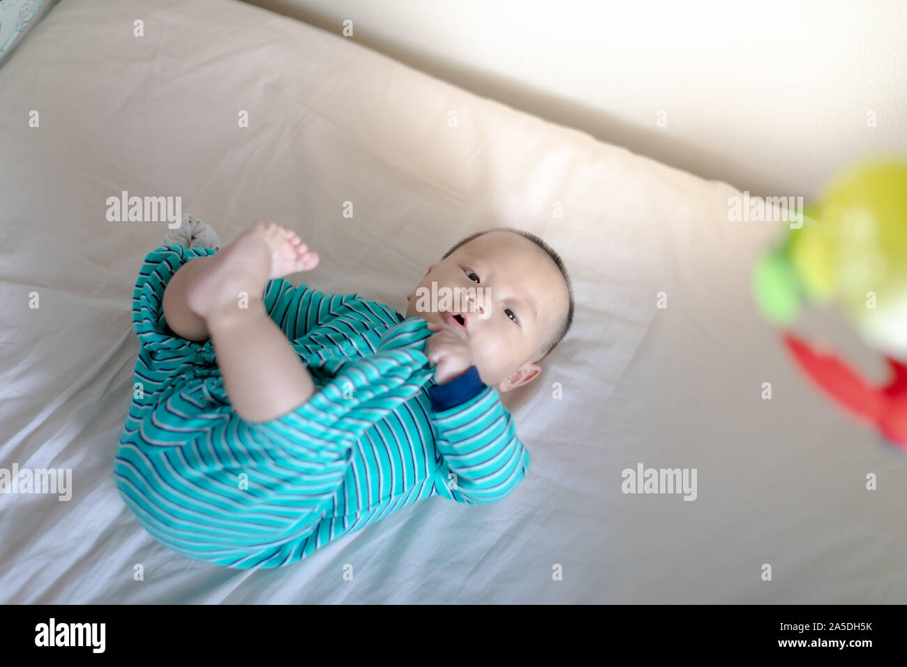 Cute baby boy rolling on bed and playing at home Stock Photo - Alamy