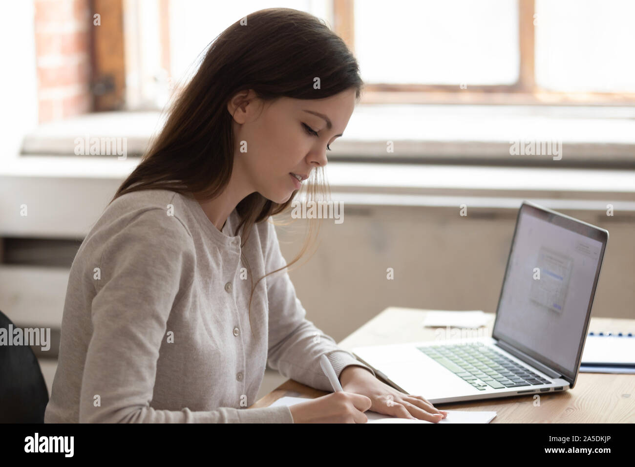 Concentrated girl sit at desk studying preparing for university session ...