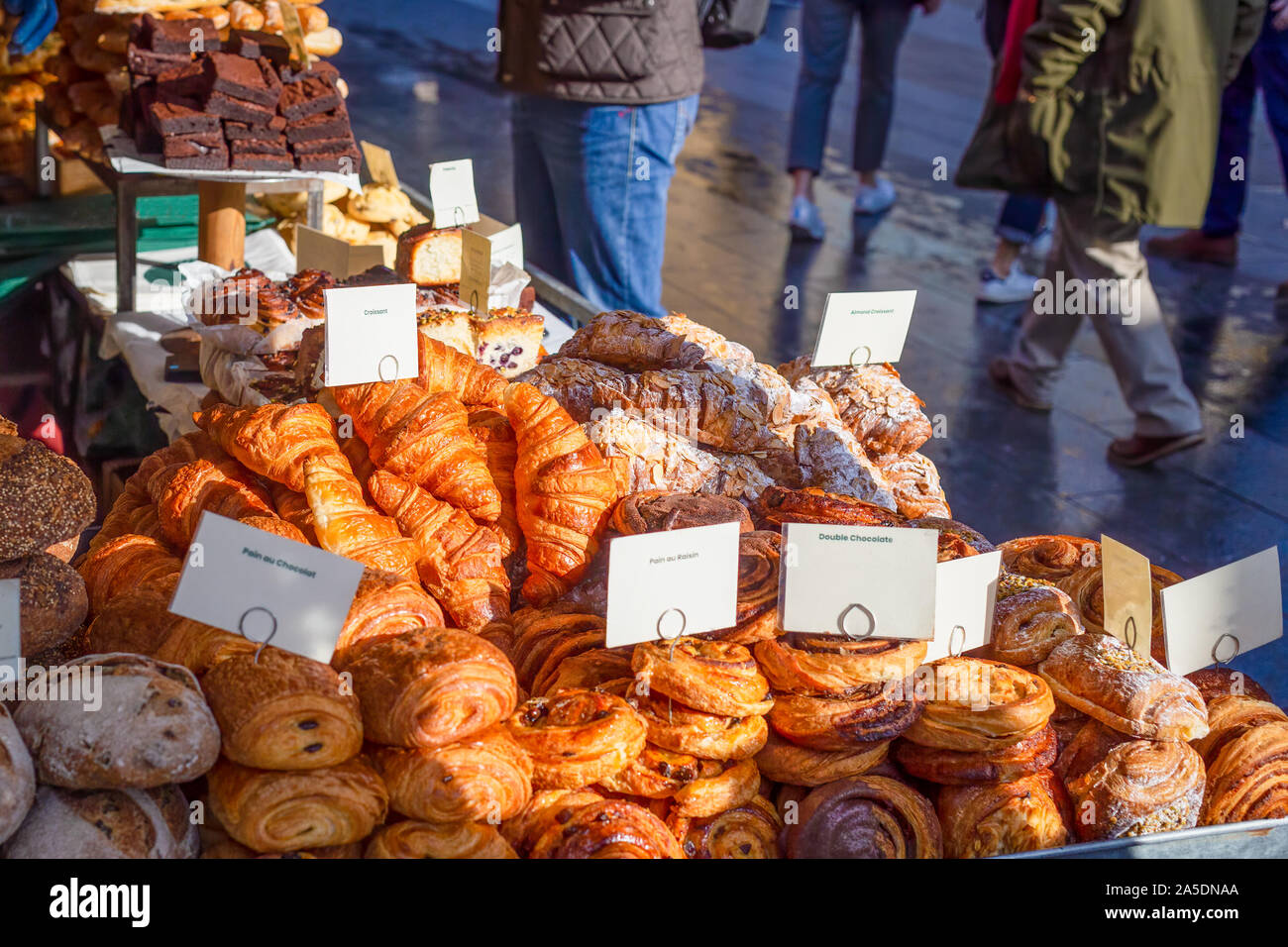Variety of artisan pastries and breads on display for sale at a street ...