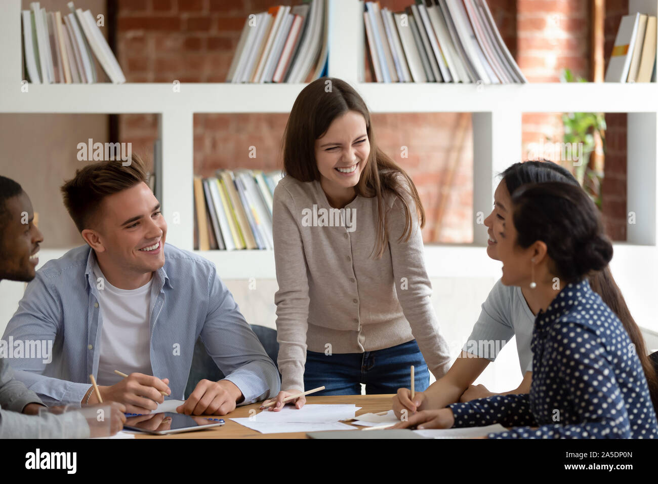Multiracial students listen caucasian girl team leader do common task ...