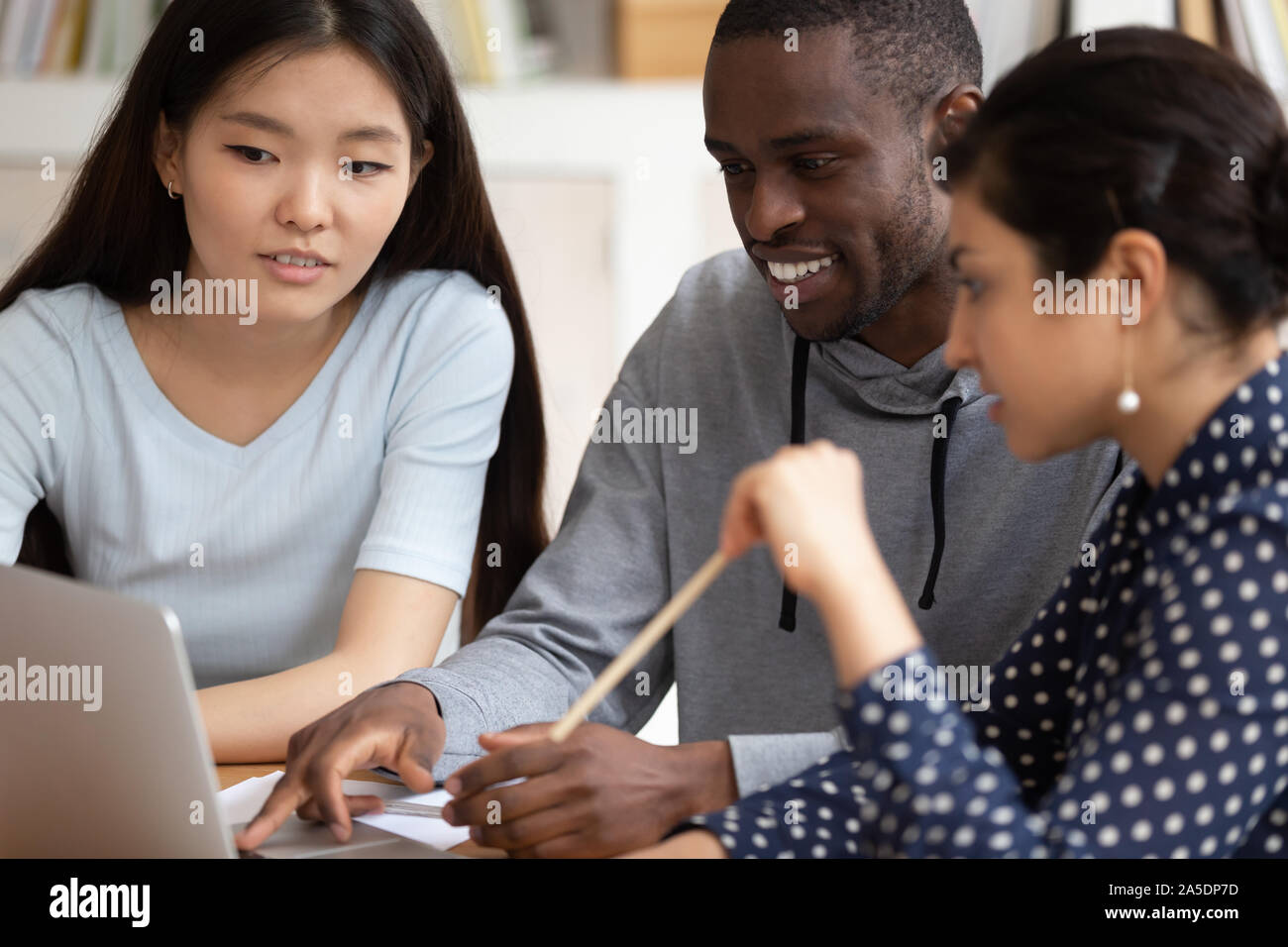 Multi-ethnic students sitting in classroom using computer educational ...