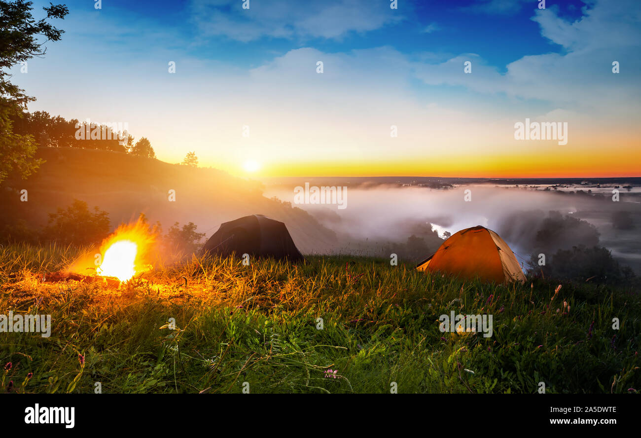Tents and bonfire in steppe near river at sunrise Stock Photo - Alamy