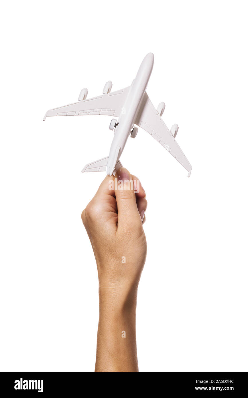 A raised female hand holds an airplane isolated on a white background ...