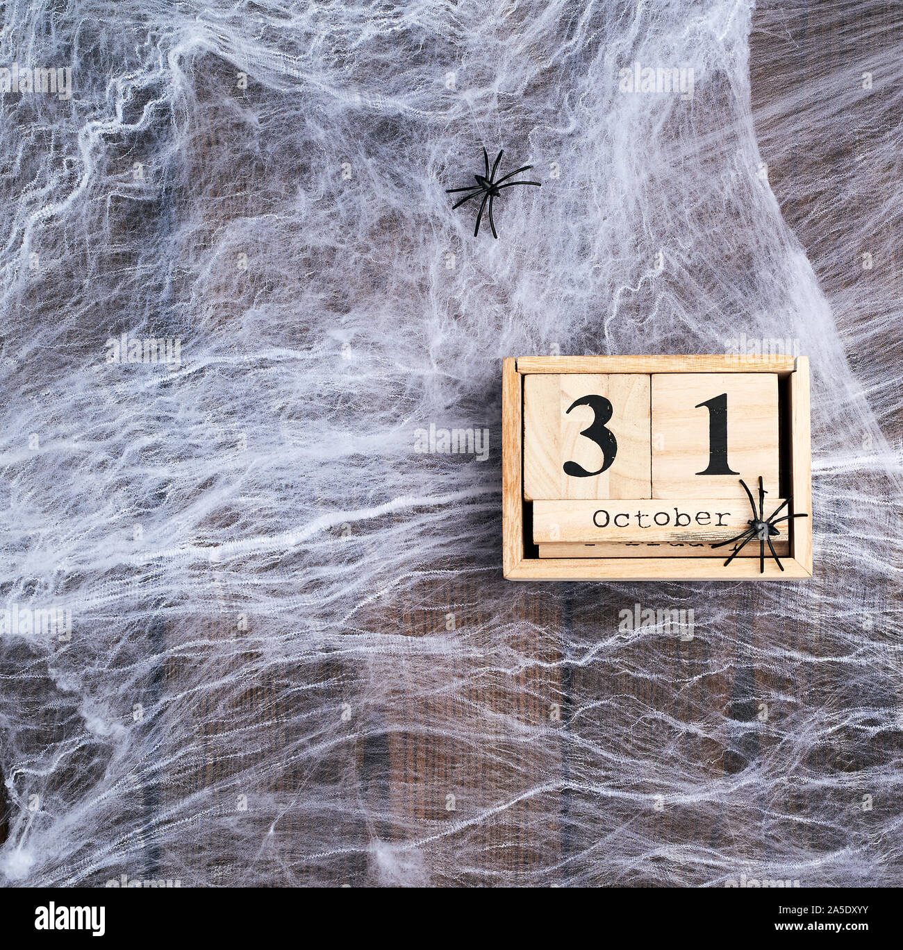 White spider web and wooden retro calendar made of blocks with the date ...