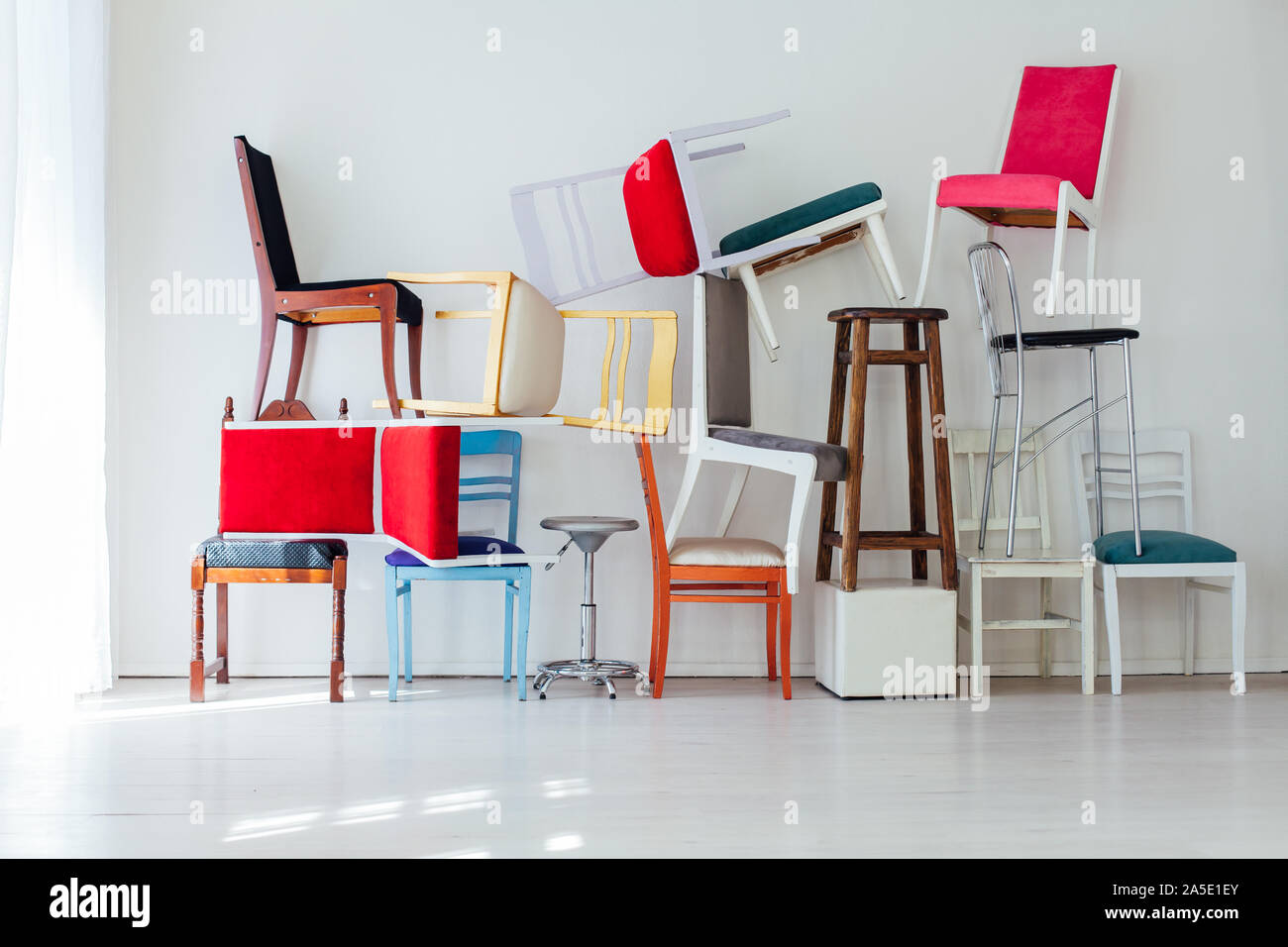 lots of different chairs in the interior of an empty white room Stock ...