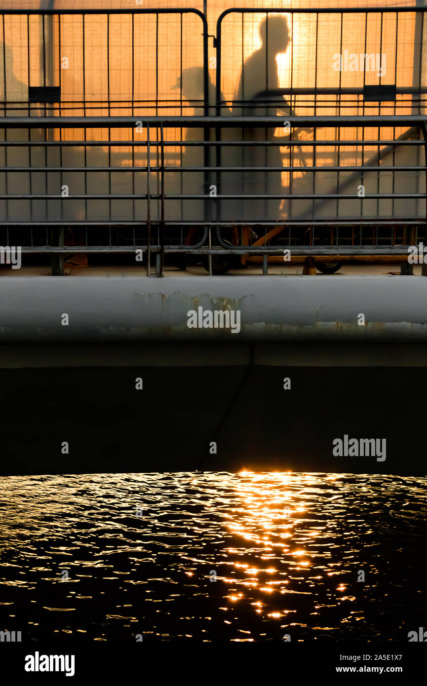 Silhouette of man walking over bridge at sunset Stock Photo - Alamy