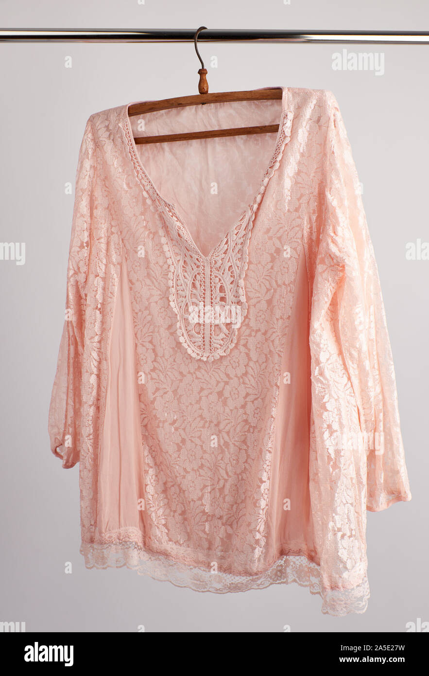 beautiful female lace blouse hanging on a wooden hanger, white ...