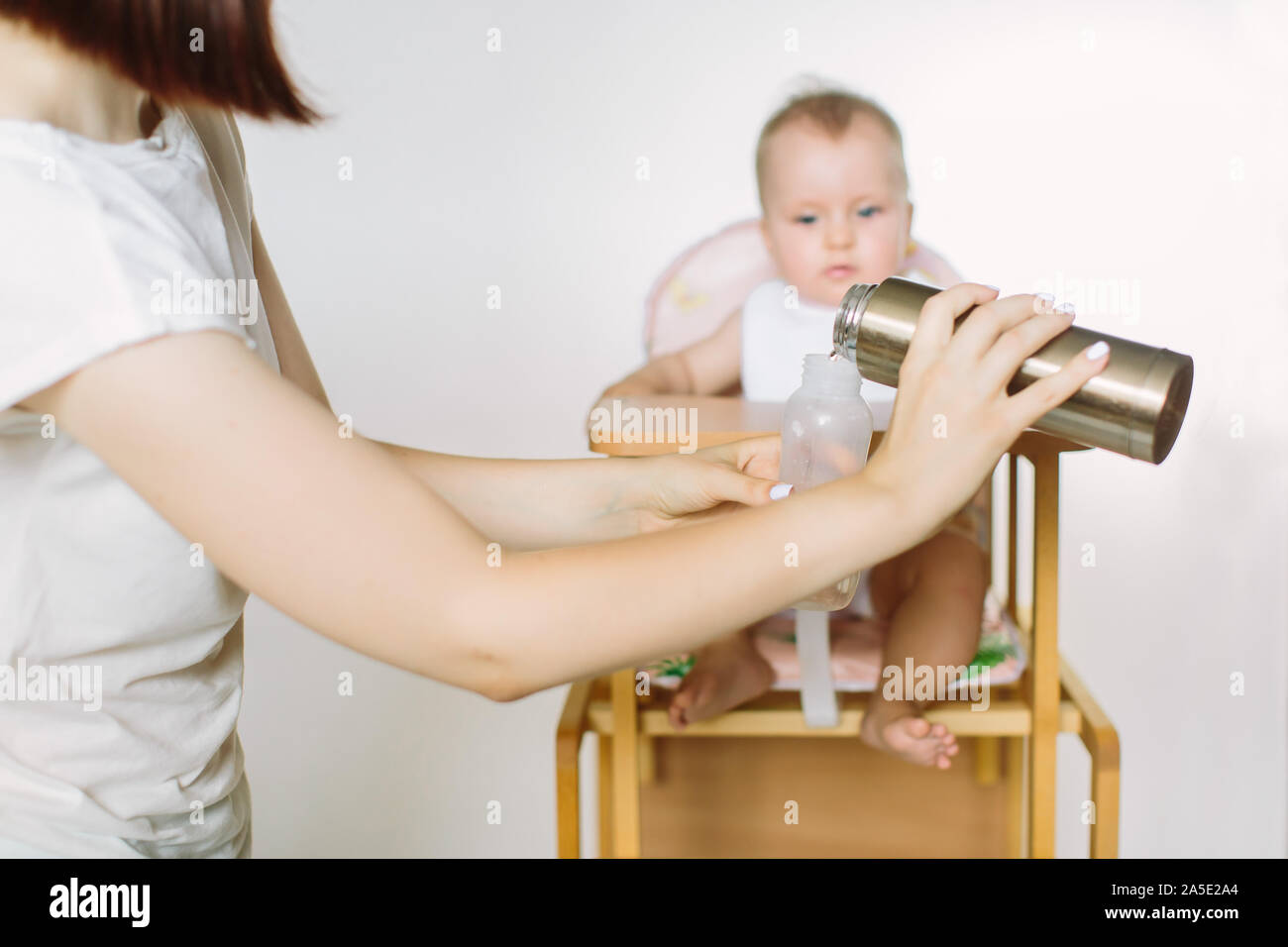 Mom pours a bottle of water, to cook food for the baby Stock Photo - Alamy