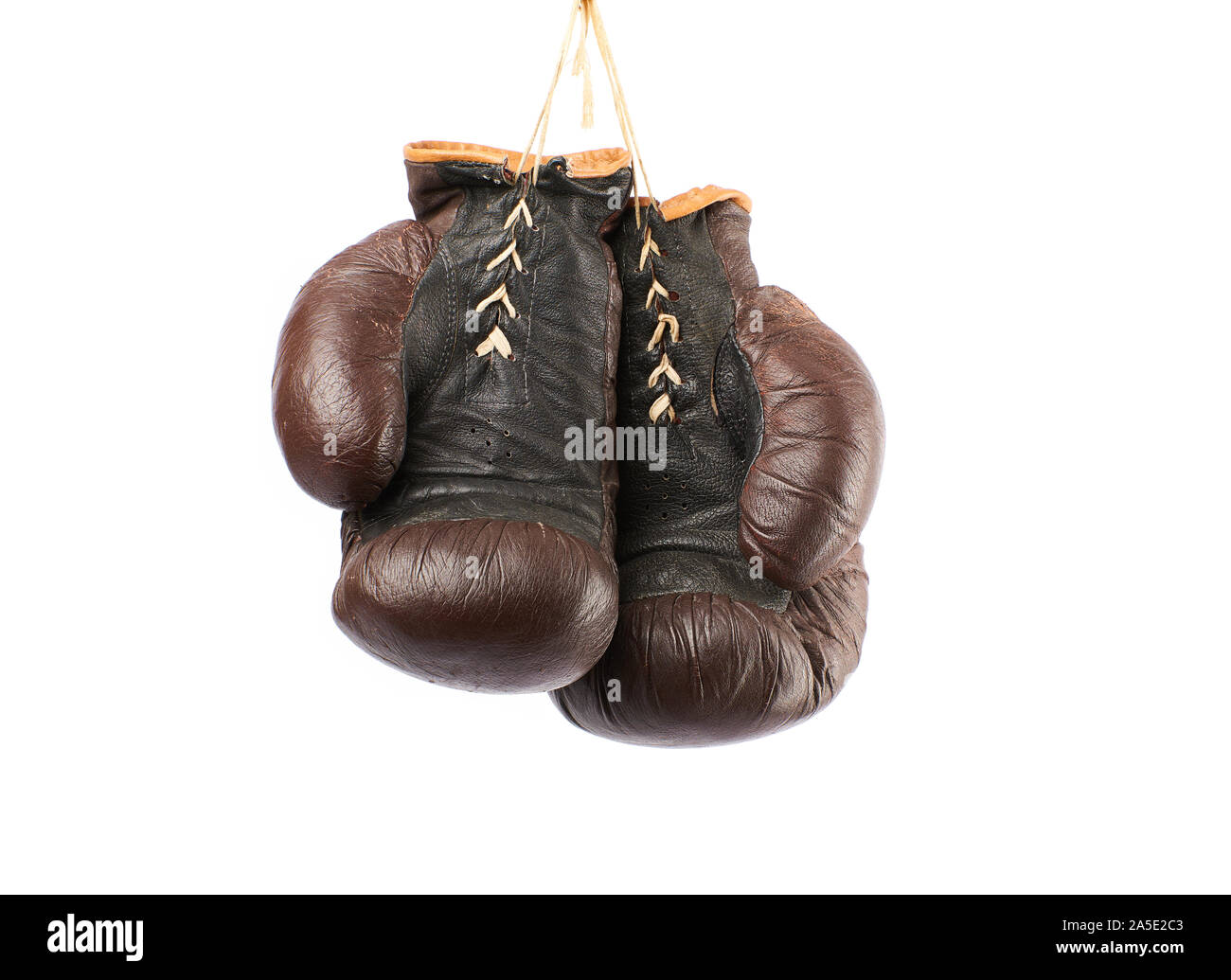 pair of very old vintage brown leather boxing gloves hanging on a rope ...
