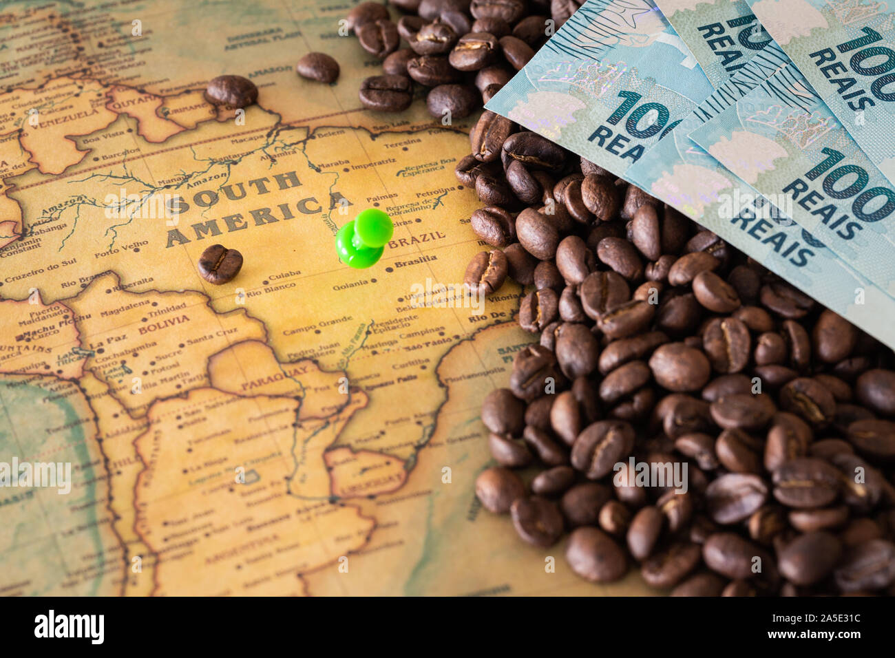 Retro map of Brazil with scattered coffee beans and 100 reais banknotes ...