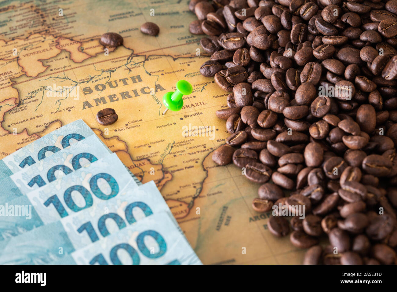 Retro map of Brazil with scattered coffee beans and 100 reais banknotes ...