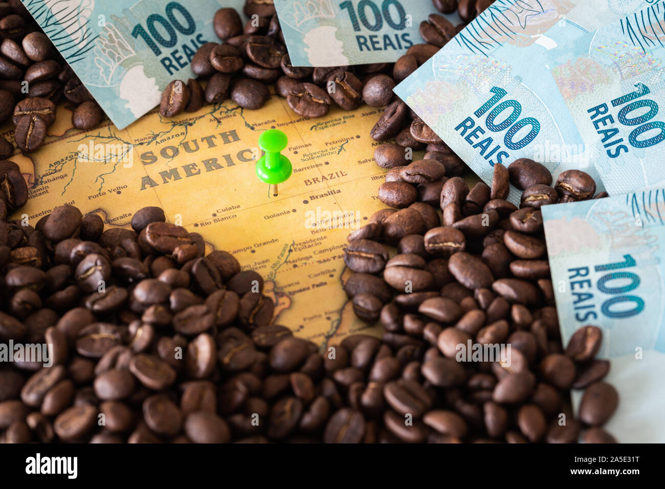 Retro map of Brazil with scattered coffee beans and 100 reais banknotes ...