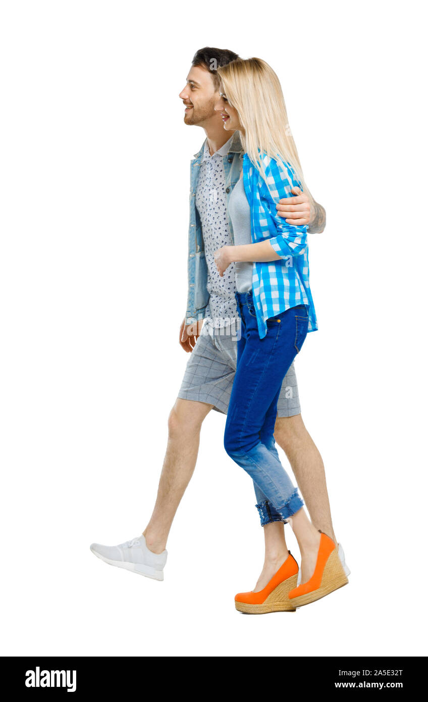 Side view of going couple. walking friendly girl and guy holding hands ...