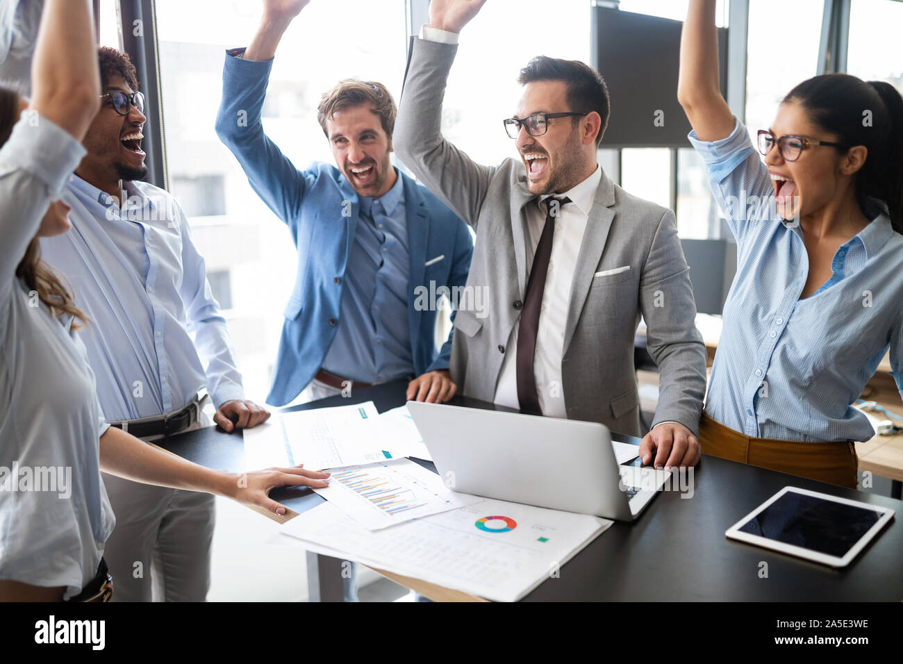Happy business people celebrating success at company Stock Photo - Alamy