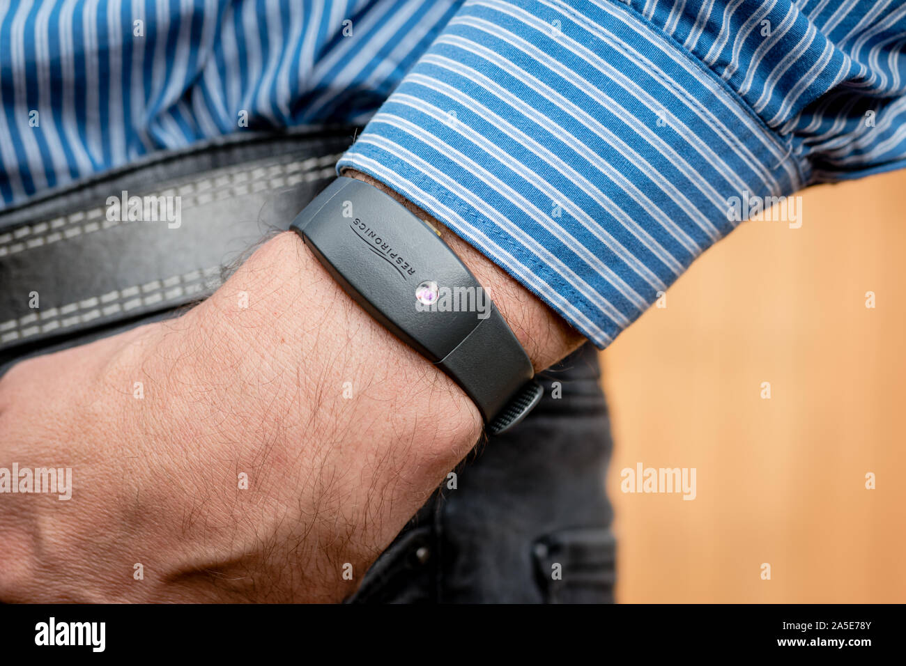 A man in a shirt wearing a Philips Respironics Actiwatch, a clinical ...